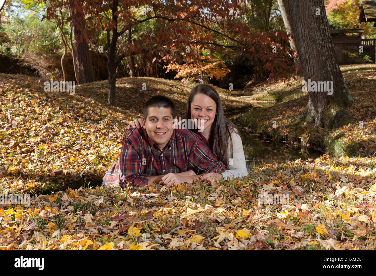Loving couple posing together during the fall / autumn, with natural ...
