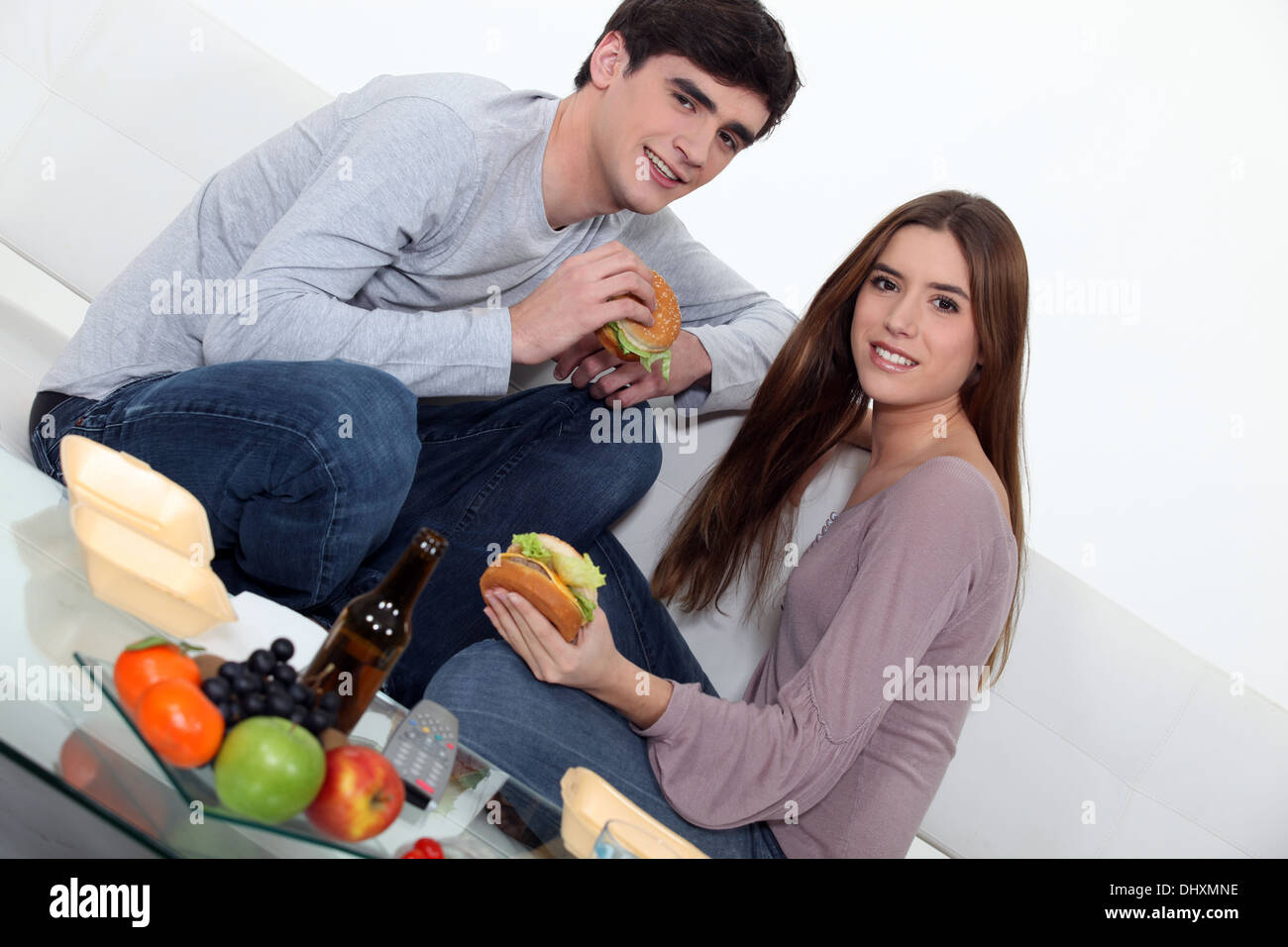 Couple eating burgers Stock Photo - Alamy