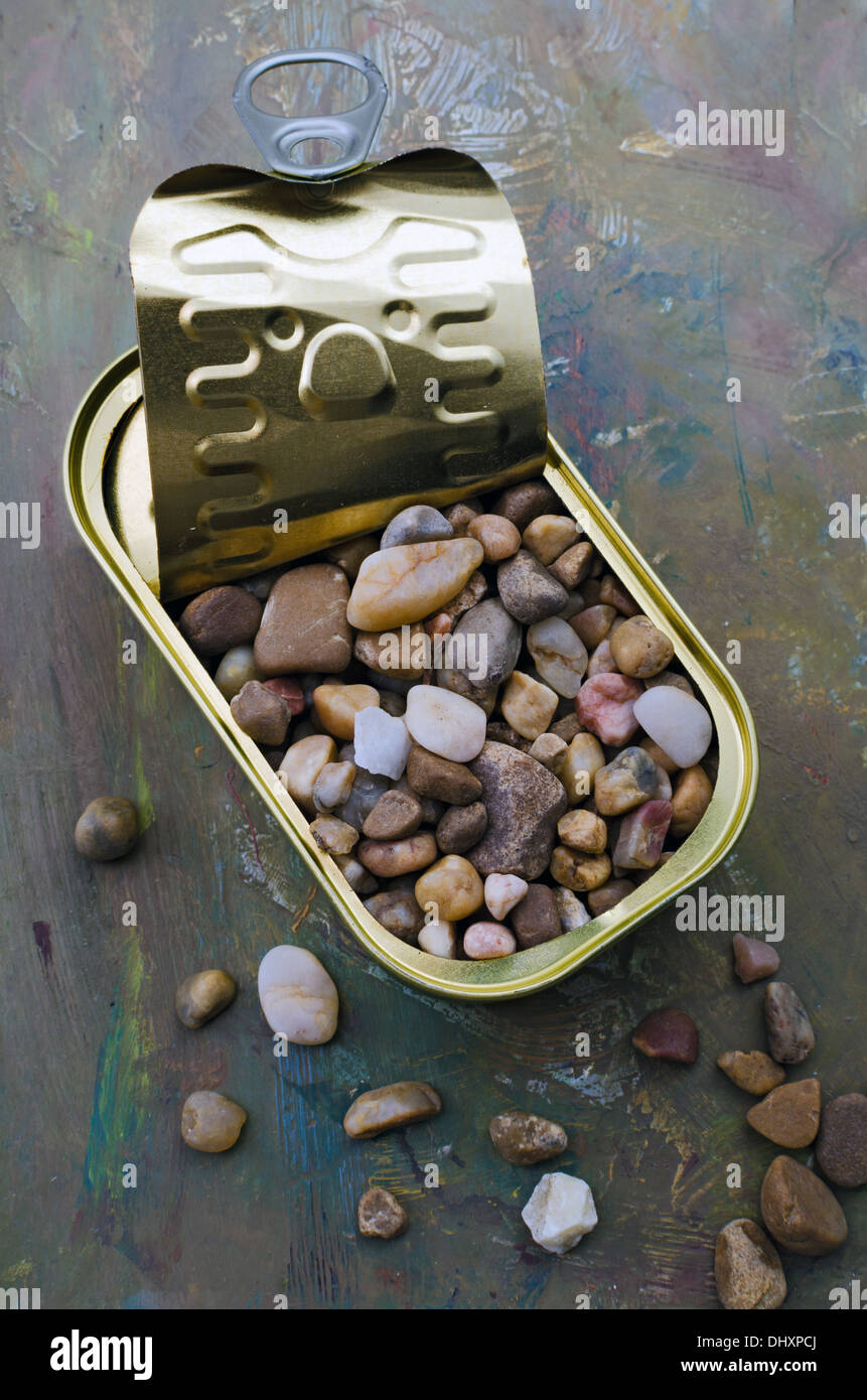 tin container filled with stones on wooden background Stock Photo - Alamy