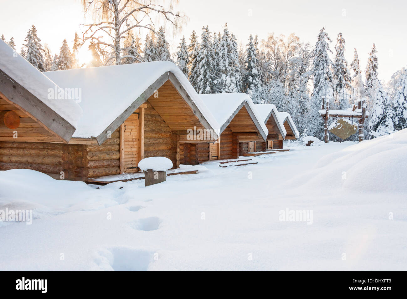 Snowy huts covered with snow at bright snowy day. Forest in background ...