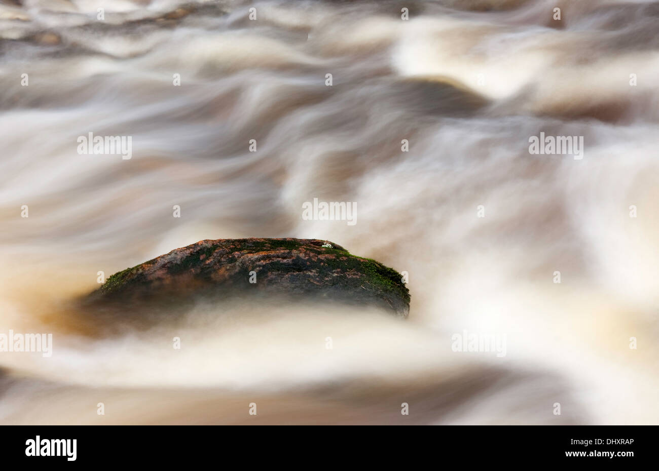Rock in flowing river Stock Photo - Alamy