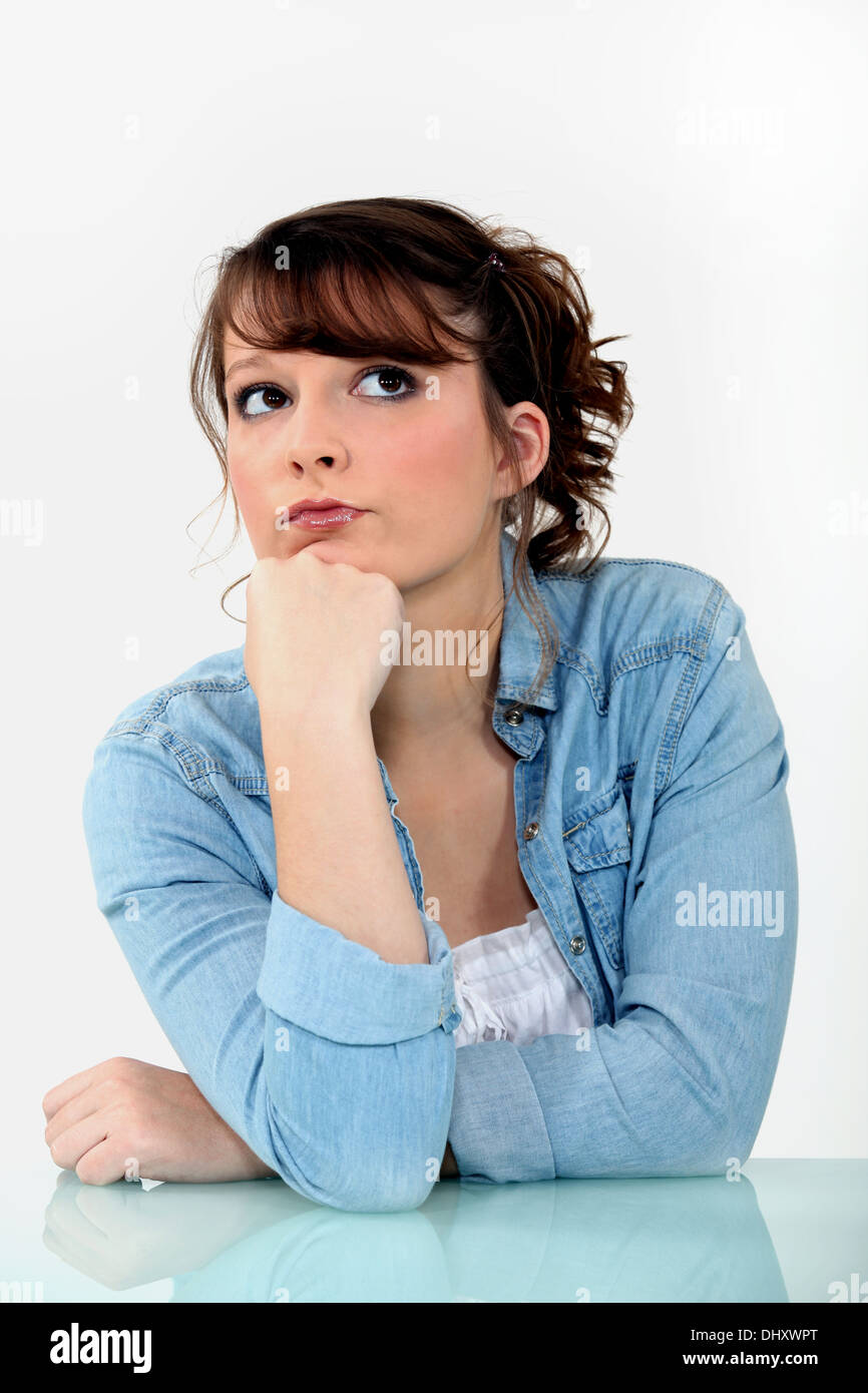 young girl looking puzzled with face resting on fist Stock Photo - Alamy