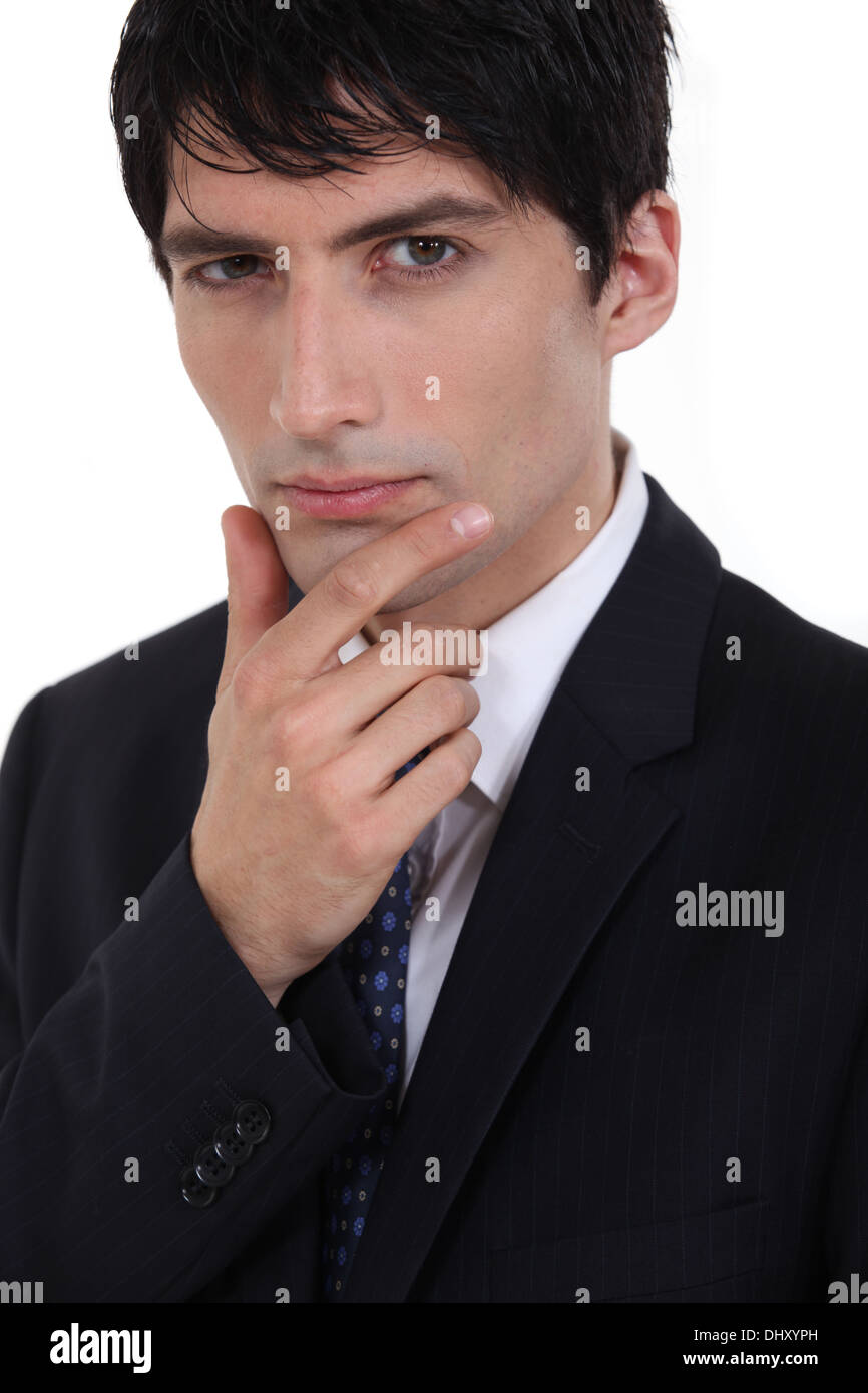 Businessman with his hand on his chin Stock Photo - Alamy
