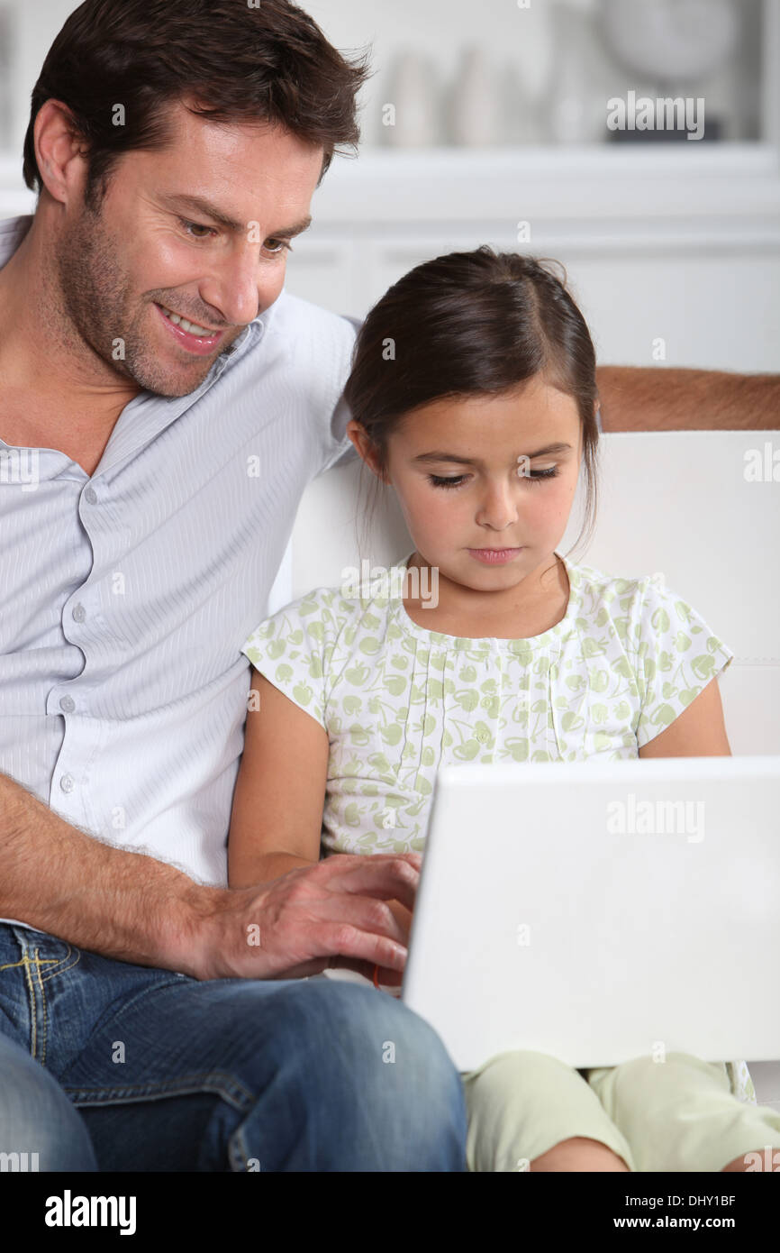 Father and daughter using computer together Stock Photo - Alamy