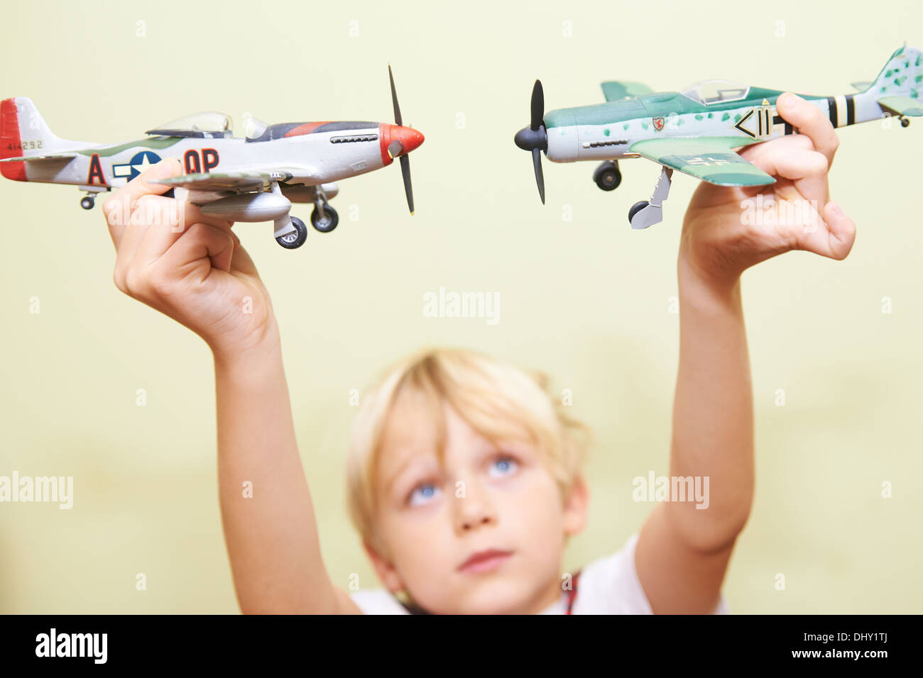 Child blond boy playing - flying with world war II airplanes fighters ...