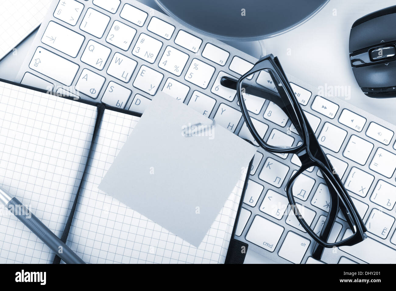 Office supplies and computer keyboard. Closeup blue toned Stock Photo ...