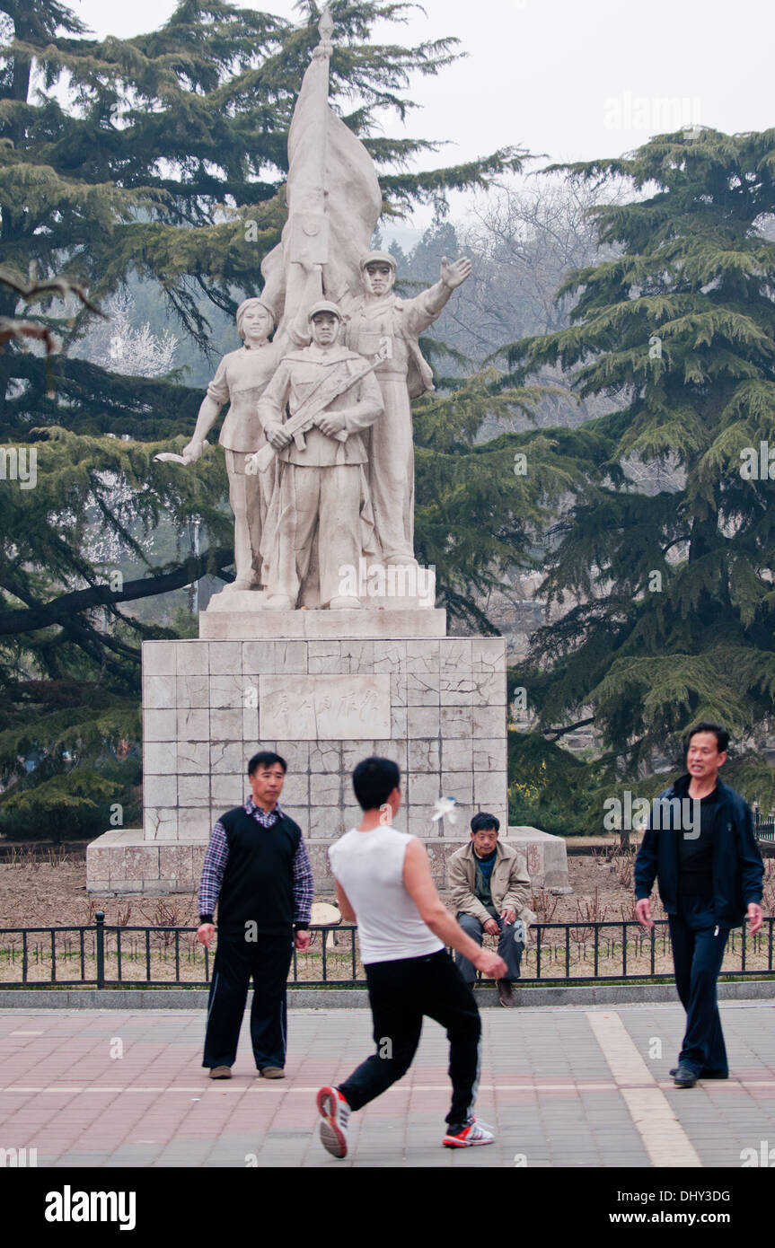 Men playing Jianzi game in front of revolutionary statue in Dongdan ...