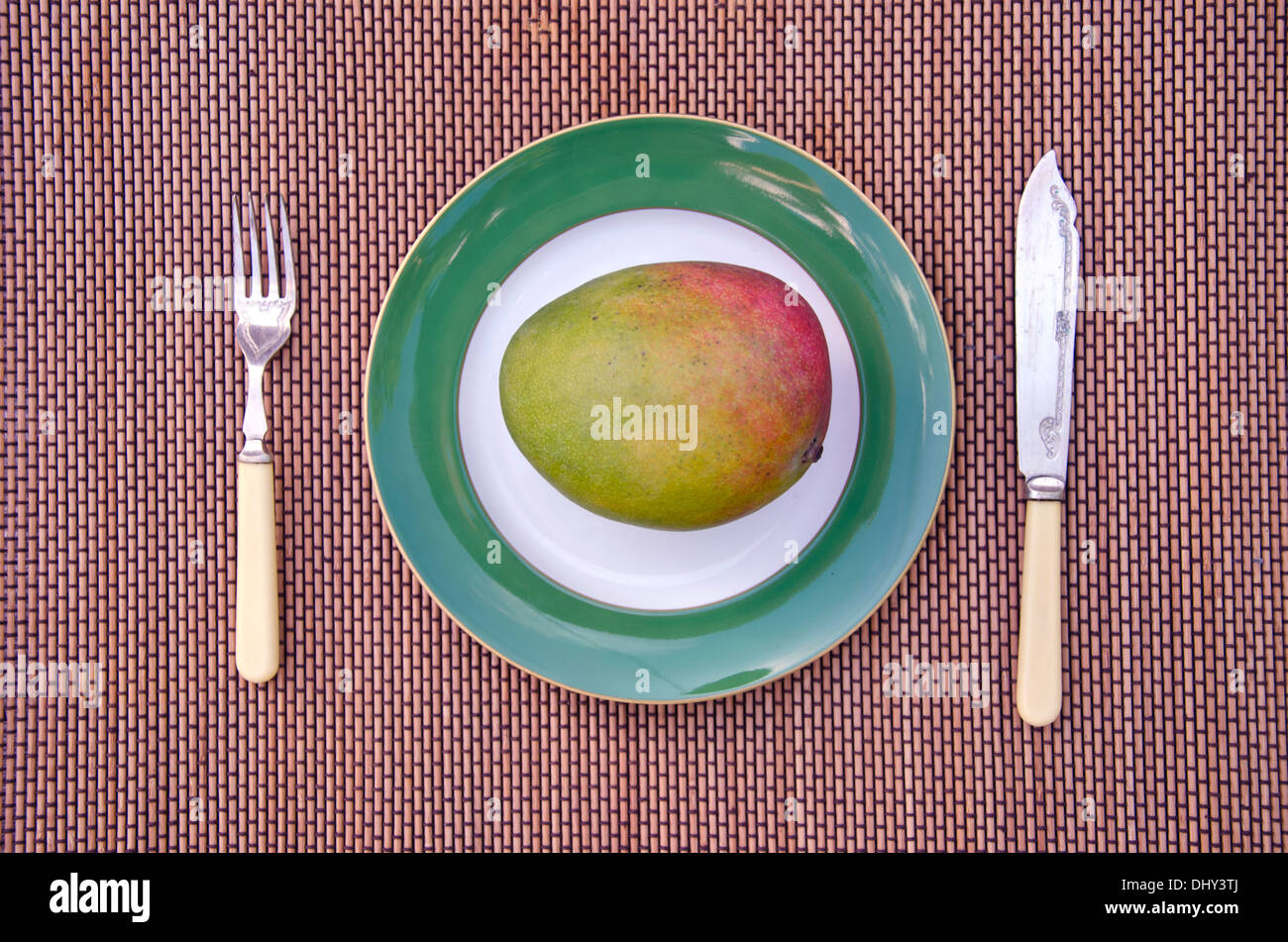 ripe mango fruit in plate with fork and knife Stock Photo - Alamy