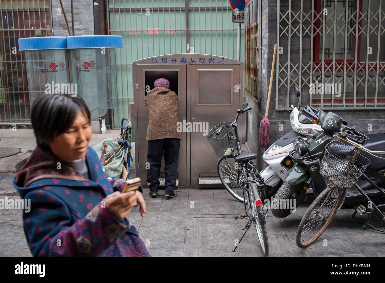 Beijing, China. 9th Nov, 2013. An old woman puts hands into the trash ...