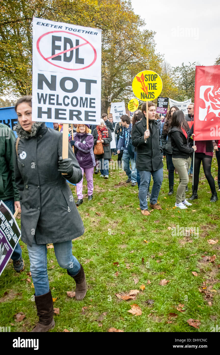 A women holds up a 'EDL Not Welcome Here', with a stop the Nazis sign ...