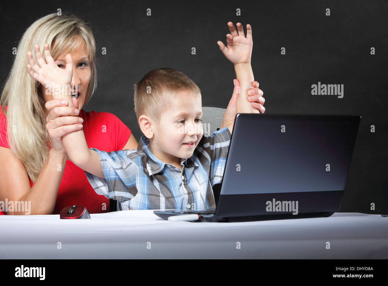 mother with son together looking on the laptop computer black ...