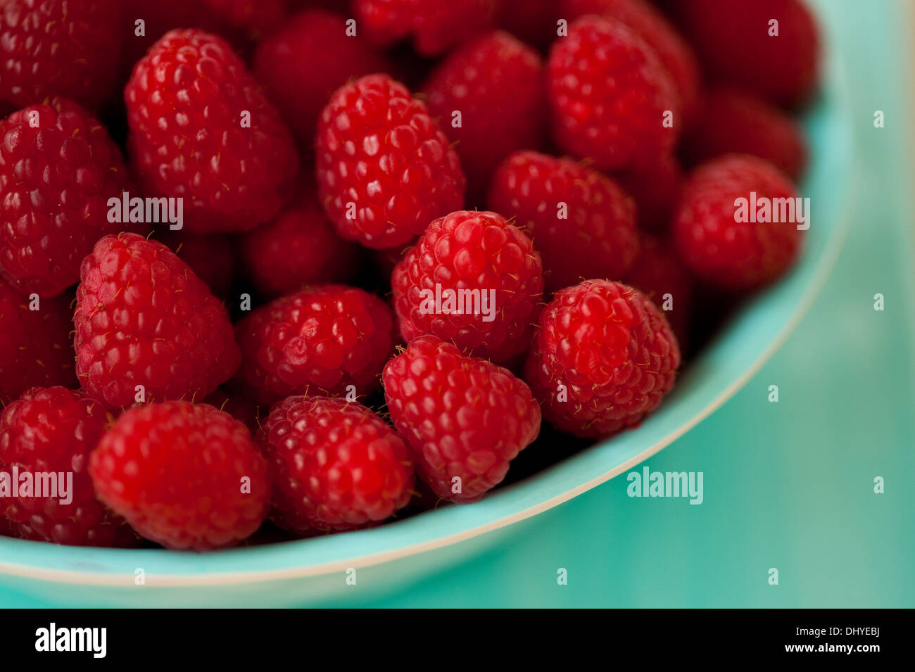 Bowl of raspberries on wood table Stock Photo - Alamy