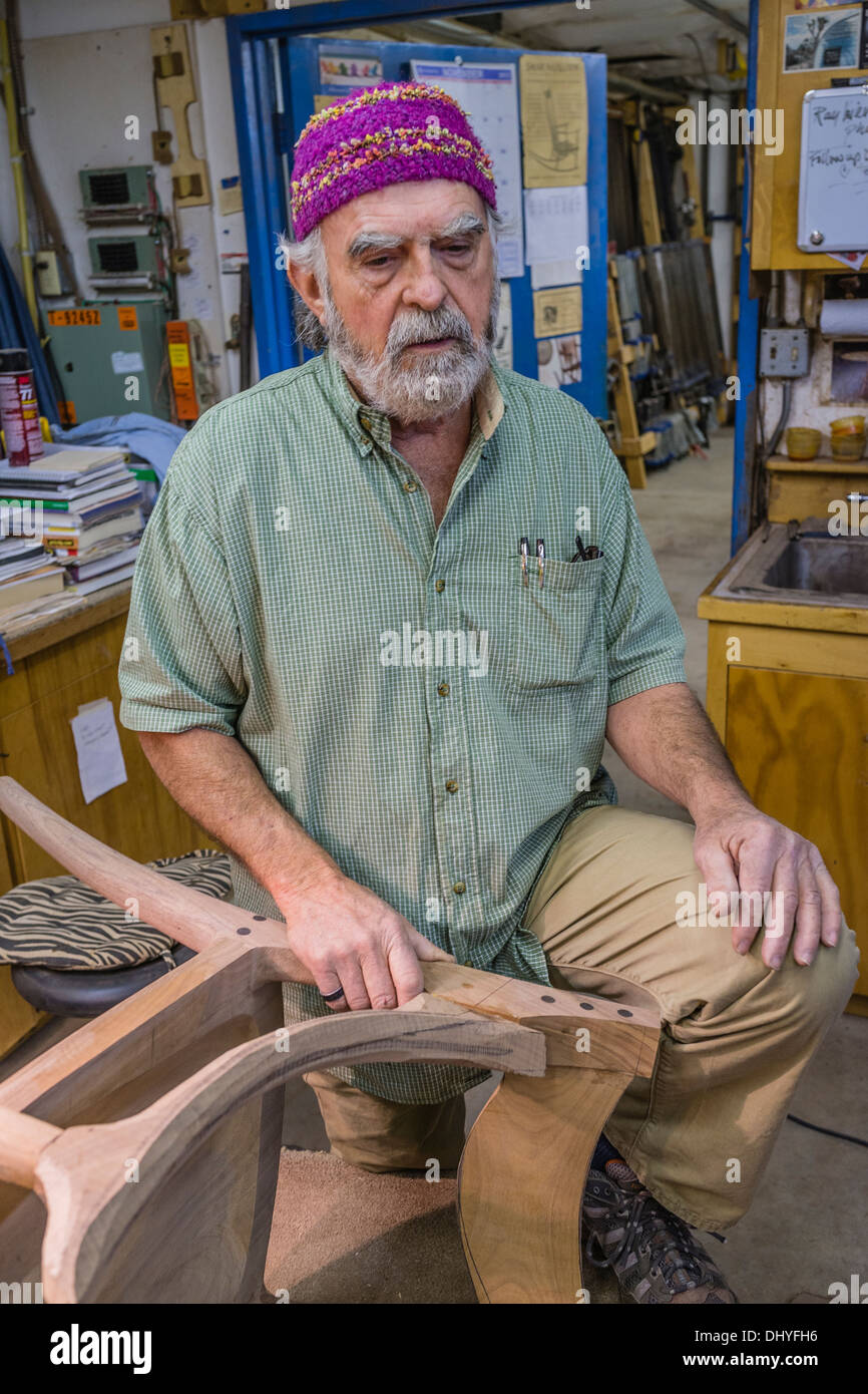Larry White, fine woodworker, stands by a chair he is creating in the ...