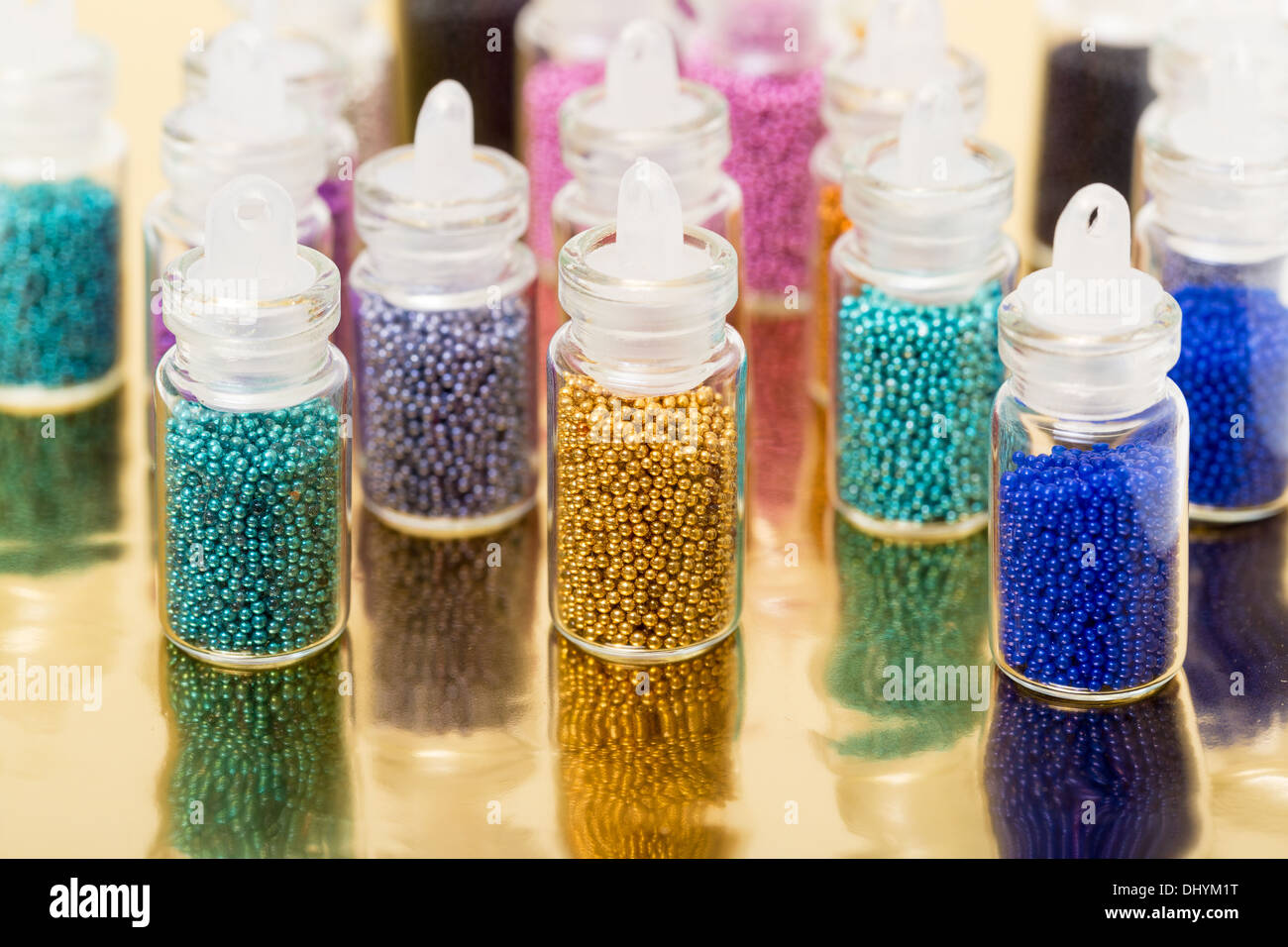 Small Glass Jars filled with Balls of Bead, on golden background Stock ...