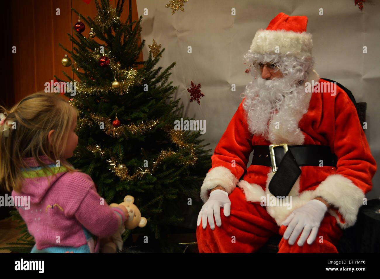 Small girl talking to Santa Stock Photo - Alamy