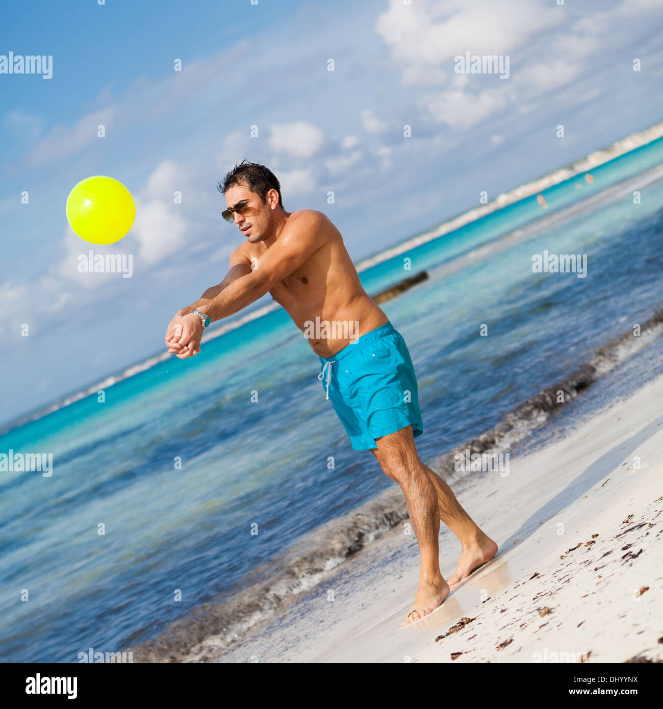 happy young adult man playing beach ball in summer sand fun sport Stock ...