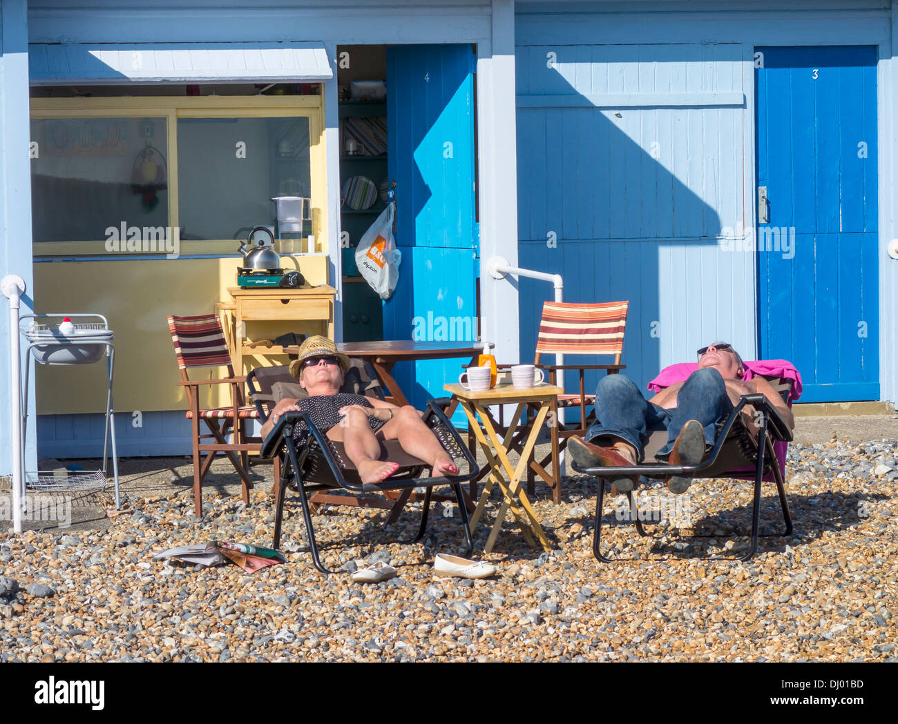 Couple asleep outside Beach Hut Stock Photo - Alamy