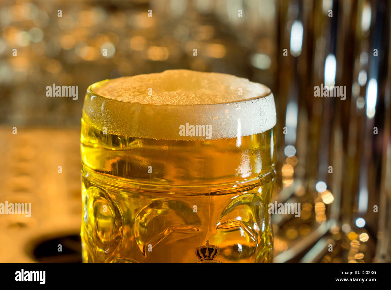 Close-up of a beer mug filled with cold foamy beer, in the diffuse ...