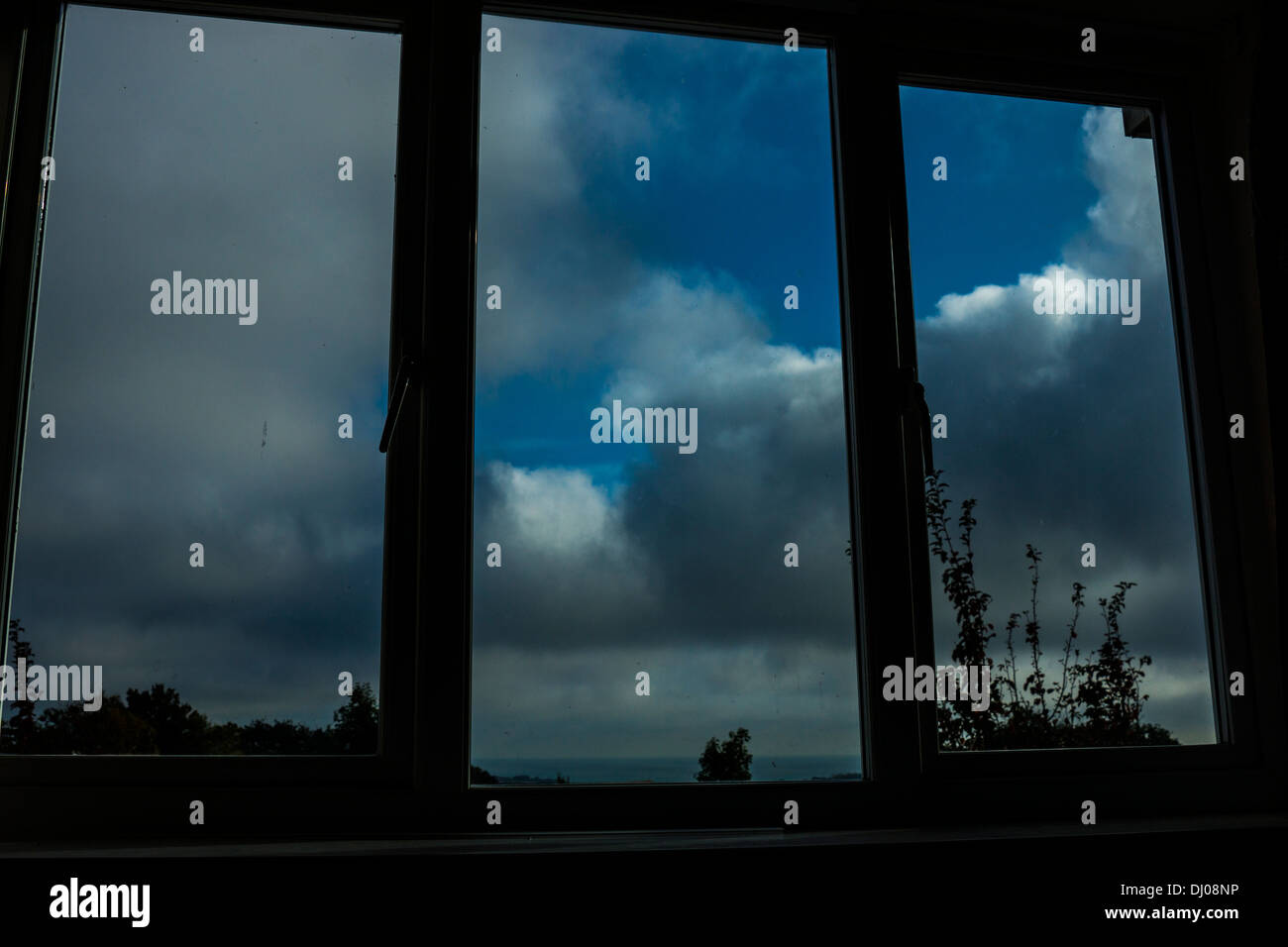 nimbus storm clouds blue sky window view trees Stock Photo - Alamy