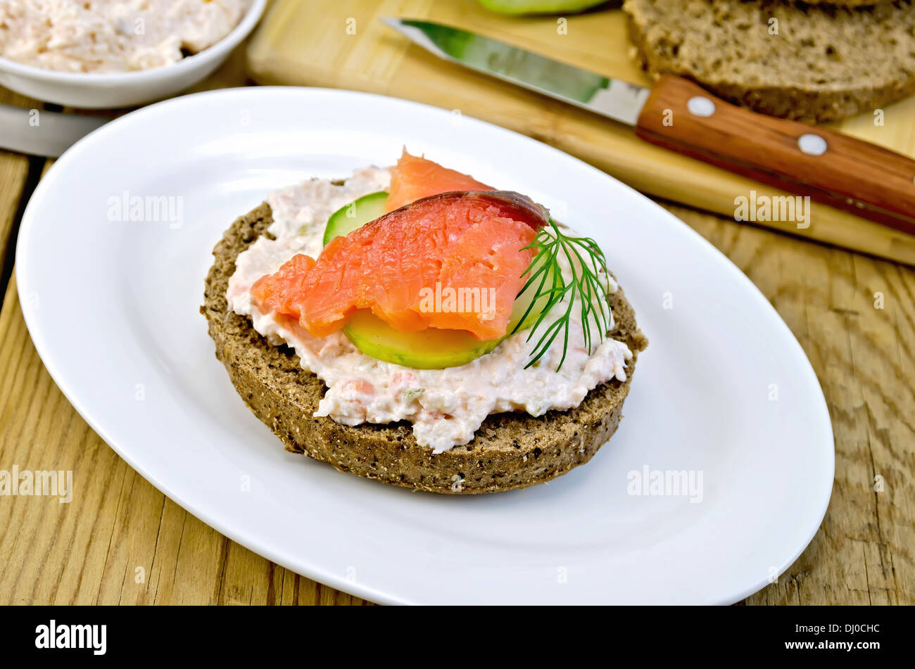 Sandwich of rye bread with cream, cucumber, dill and salmon on a plate ...