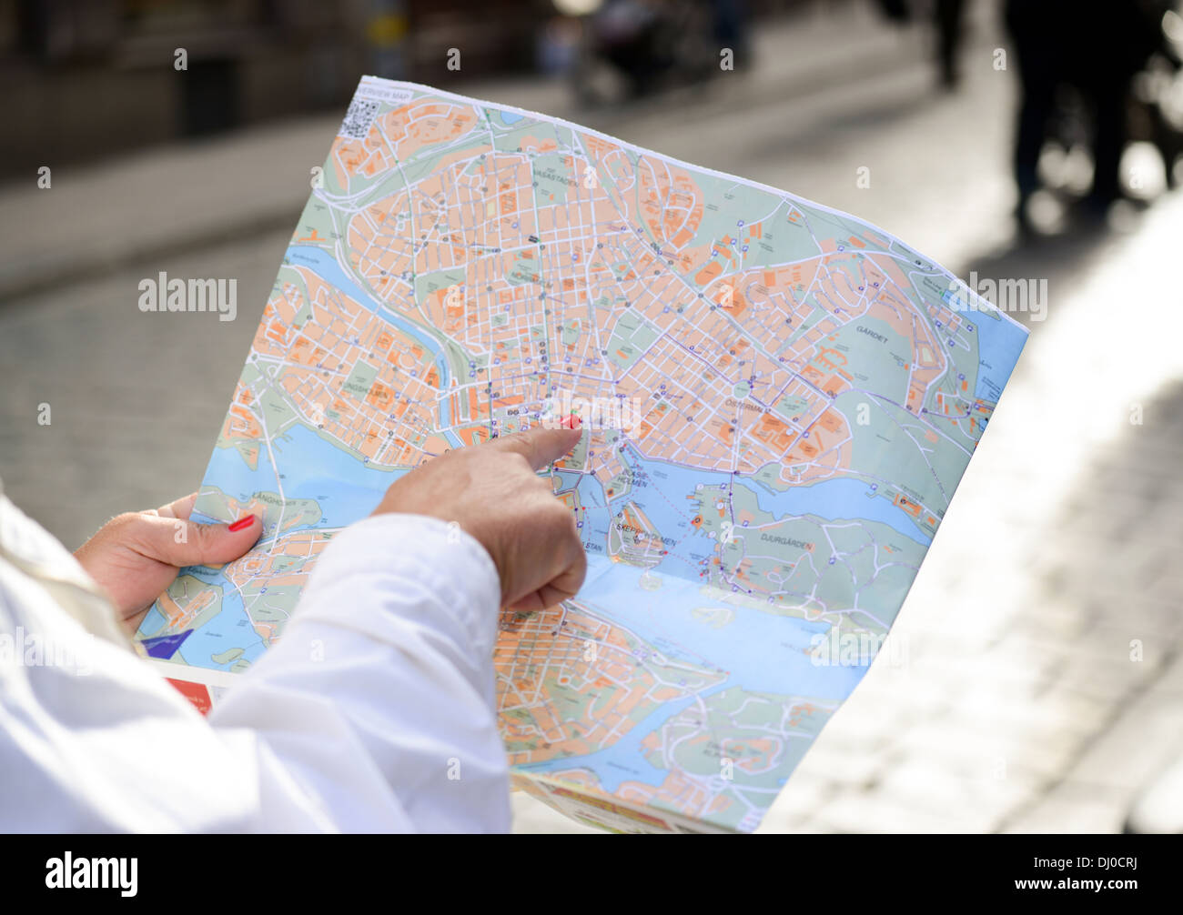 Tourist hand pointing at City map Stock Photo - Alamy