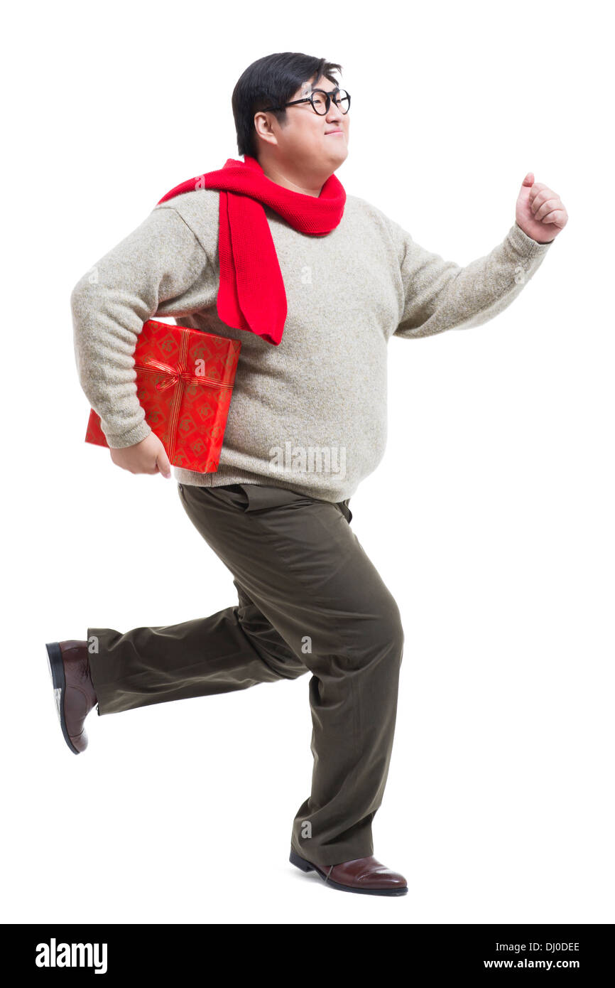 Excited young man with Chinese New Year's gift running Stock Photo - Alamy