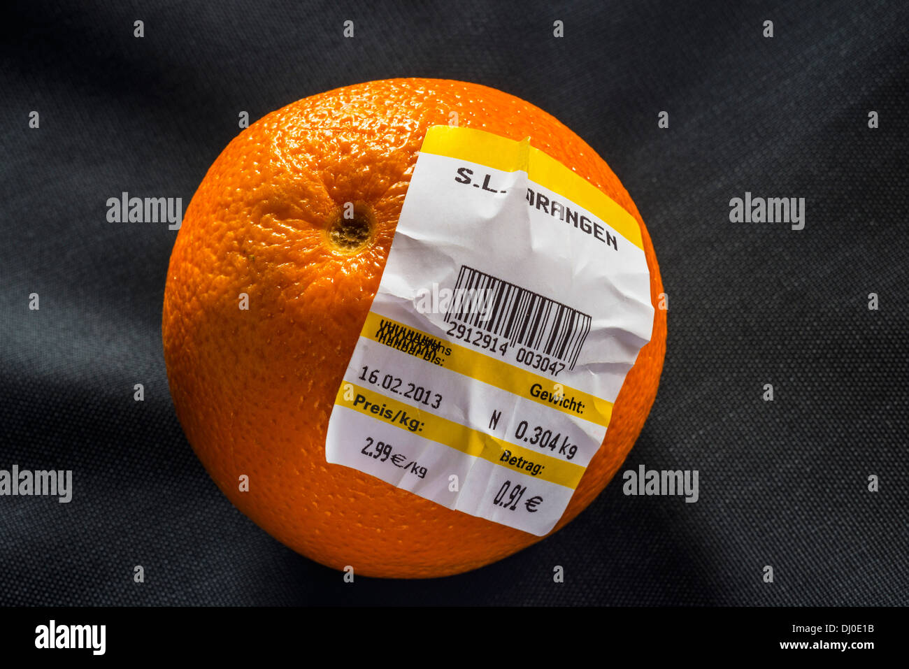 One orange with German bar-coded label showing weight and price in Euro ...