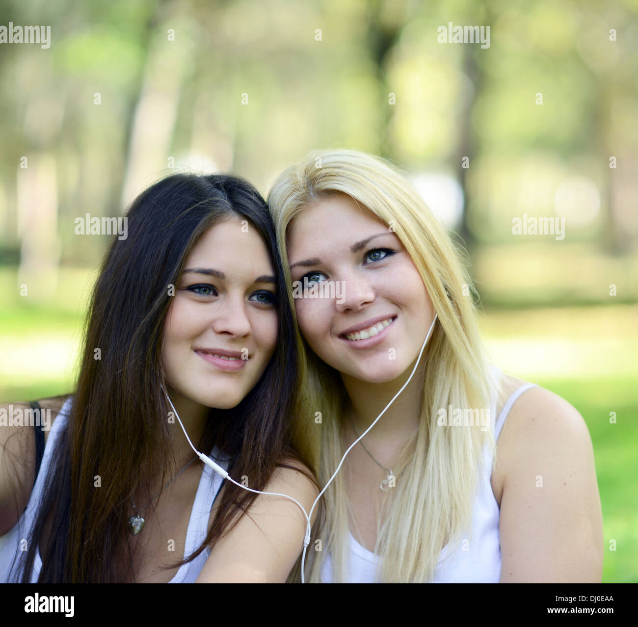Two teenage girls listening to music outdoors Stock Photo - Alamy