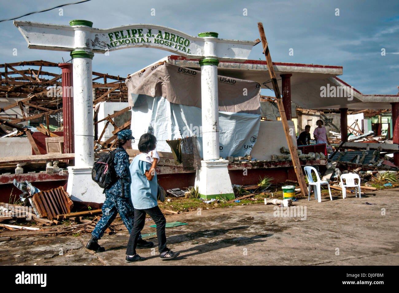 A US Navy physician assistant walks with a Filipino nurse pas the ...
