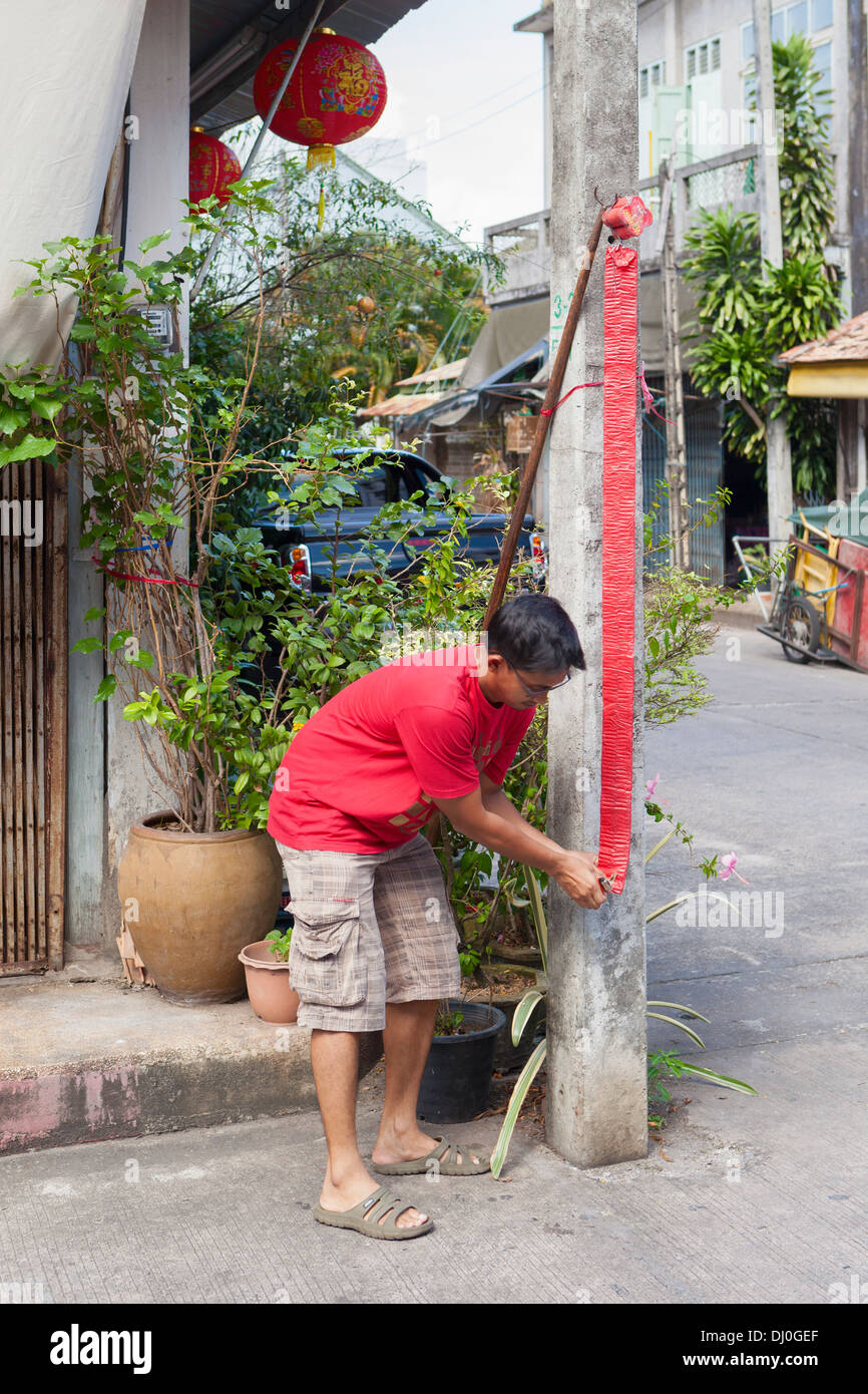 Lighting firecrackers for Chinese new year, Thailand Stock Photo - Alamy