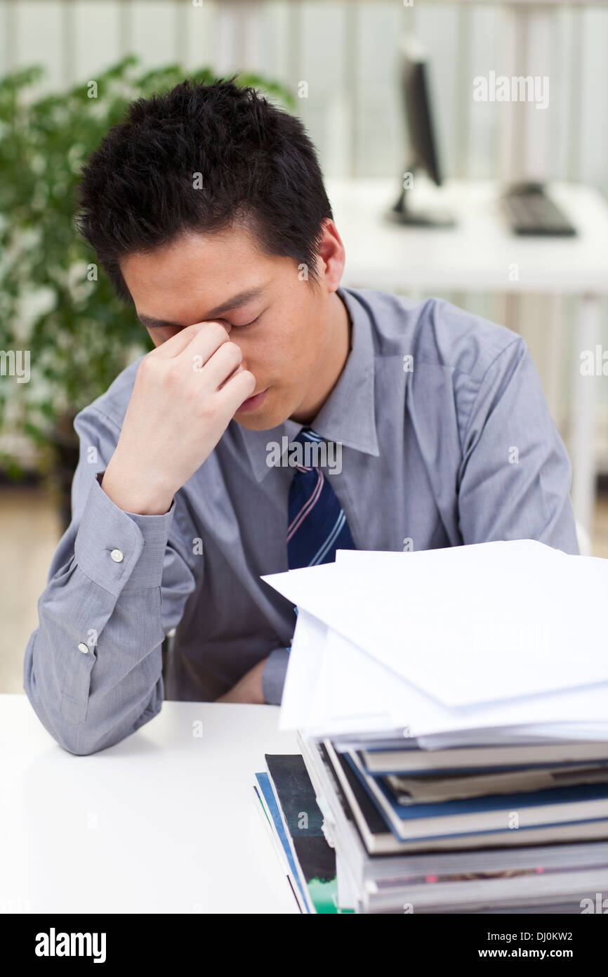 A man looks stressed as he works at his desk Stock Photo - Alamy