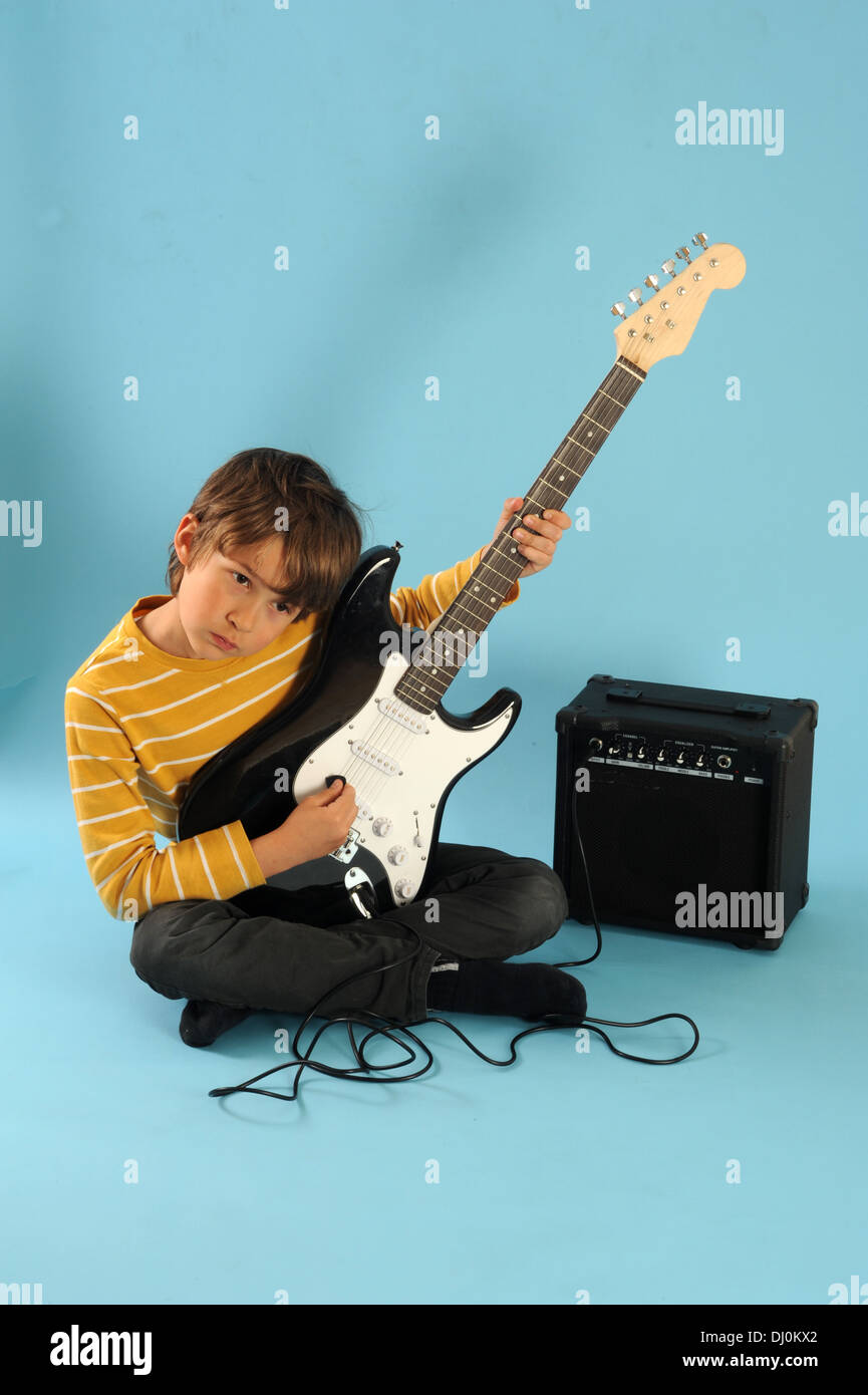 Boy playing an electric guitar Stock Photo - Alamy