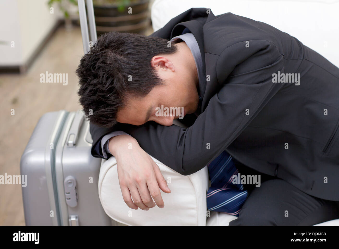 Businessman resting head on pile of boot Stock Photo - Alamy
