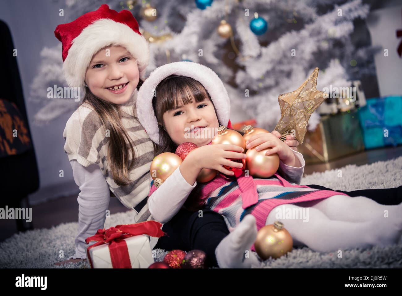 two little girls getting Christmas Tree decoration Stock Photo - Alamy
