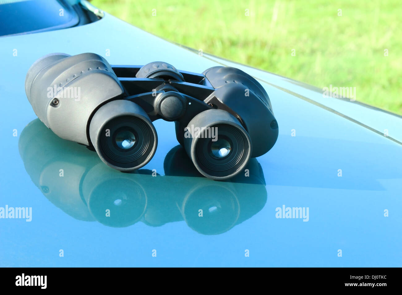 On the hood of a blue car is the binoculars Stock Photo - Alamy