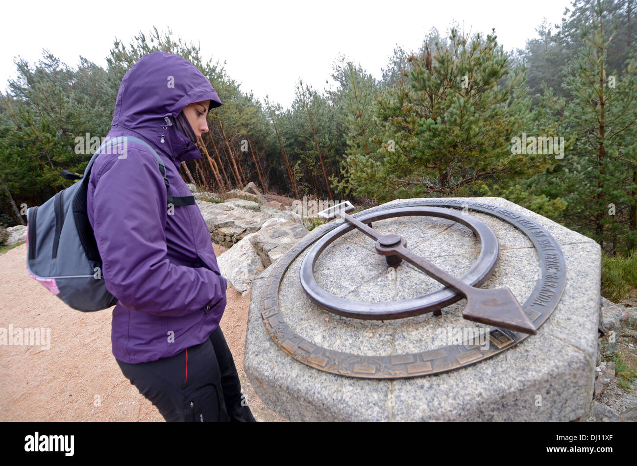 Young woman looking at compass on a rock while hiking in PeÃ±alara ...