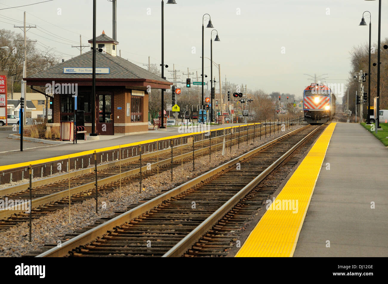 Suburban commuter train approaching station Stock Photo - Alamy