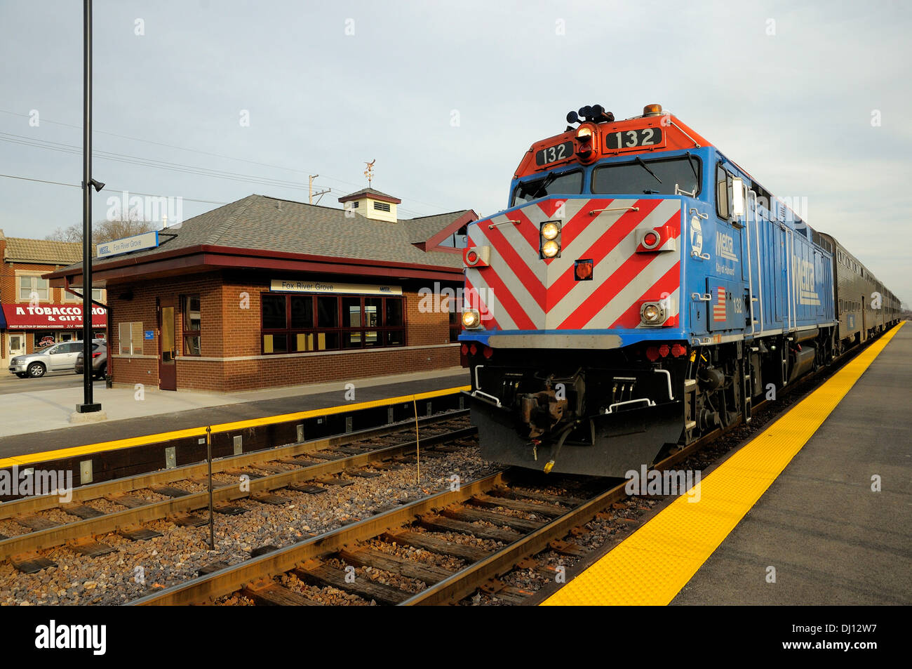 Suburban commuter train approaching station Stock Photo - Alamy