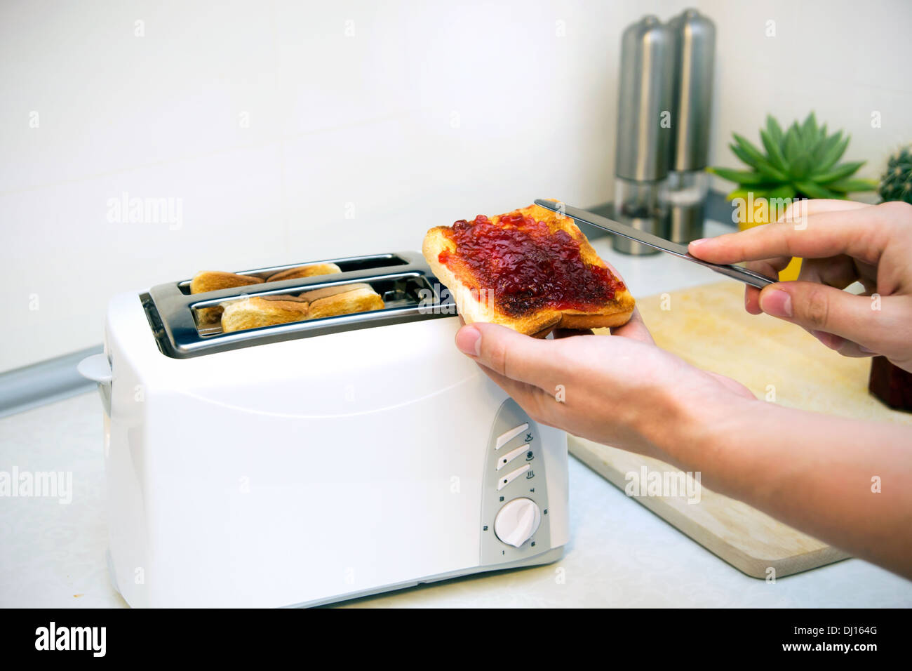 Preparing toast with jam for breakfast Stock Photo - Alamy