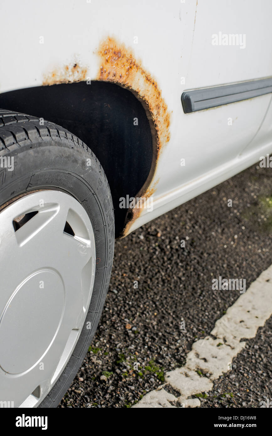 Rust damage around wheel housing on white car Stock Photo - Alamy
