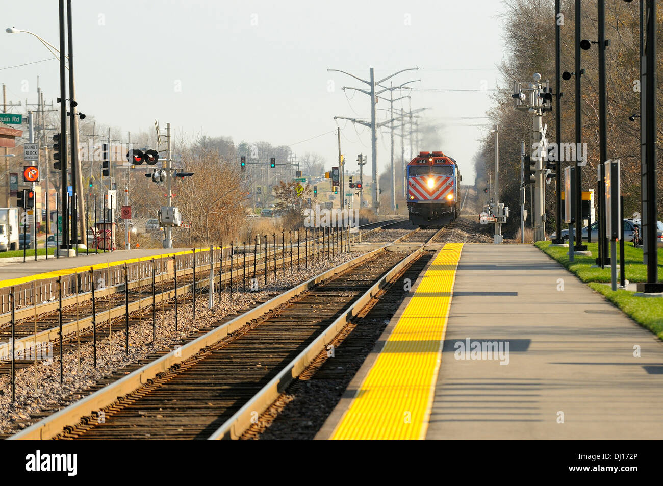 Suburban commuter train approaching station Stock Photo - Alamy
