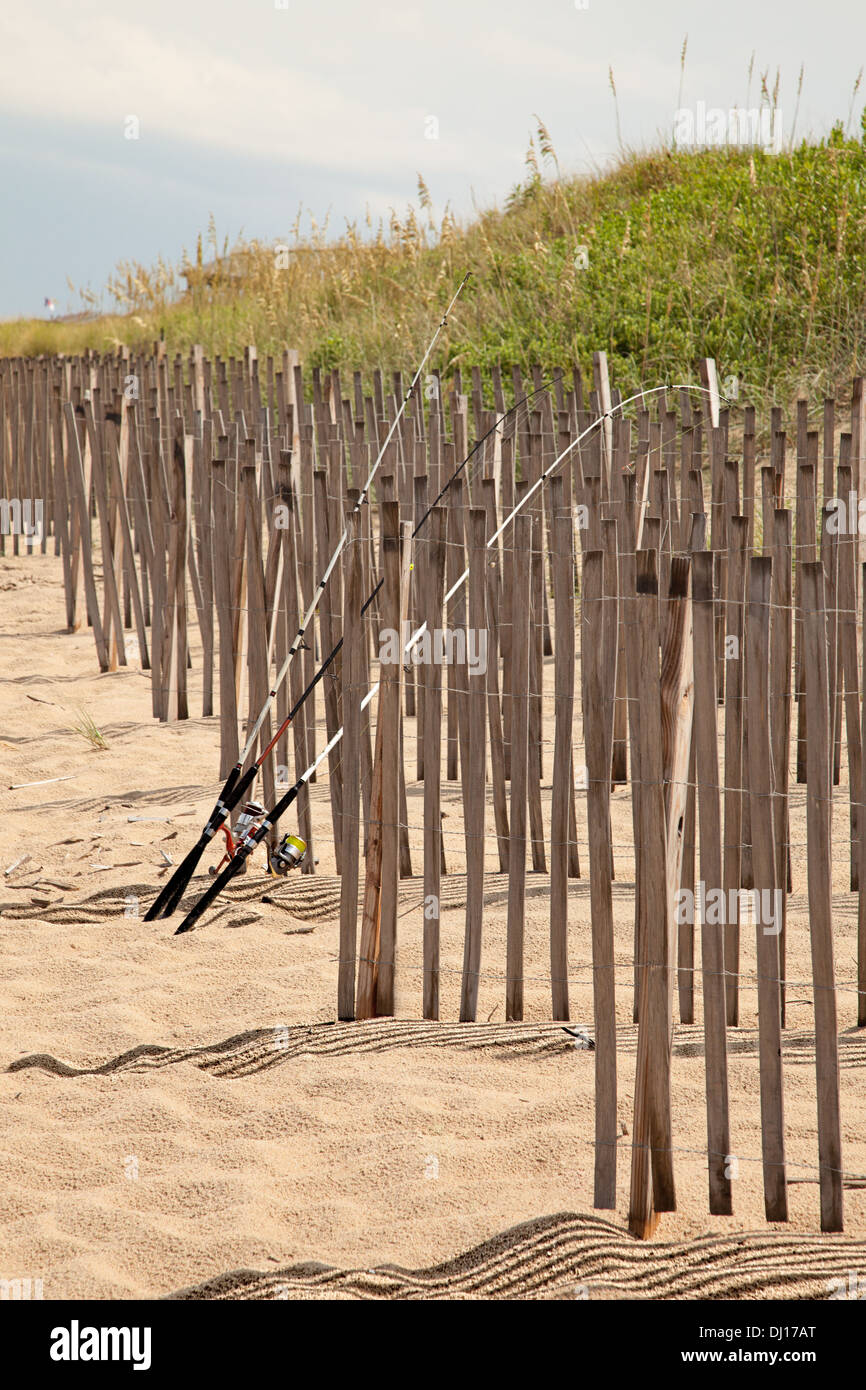 Fishing poles on beach fence Stock Photo - Alamy