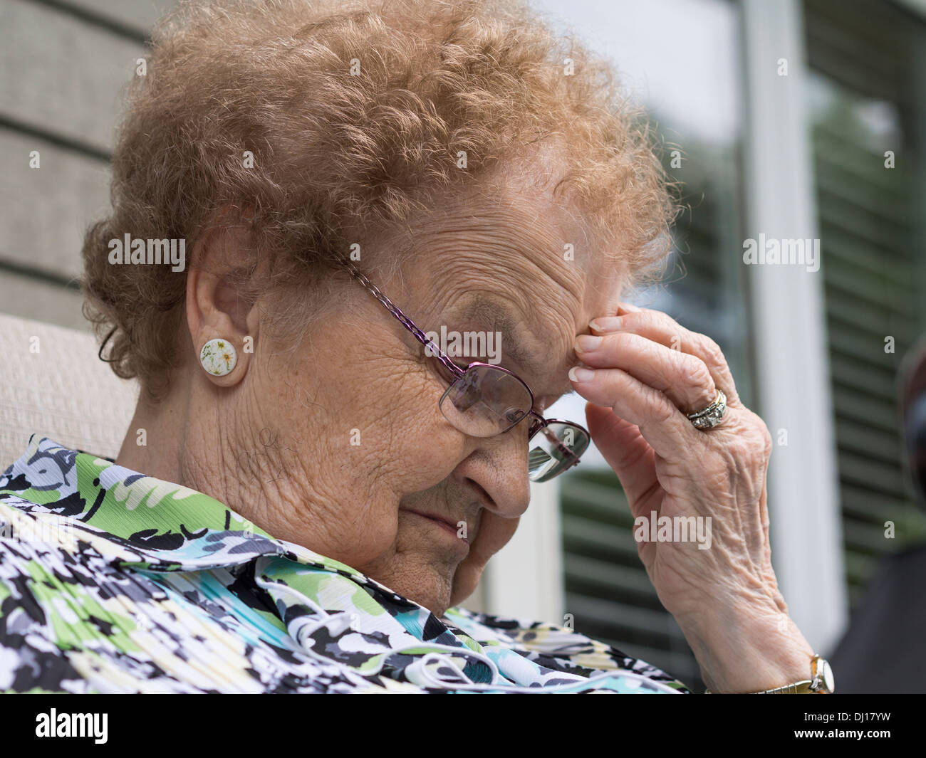 Senior Woman Thinking. An older woman, eyes down, scratching forehead ...