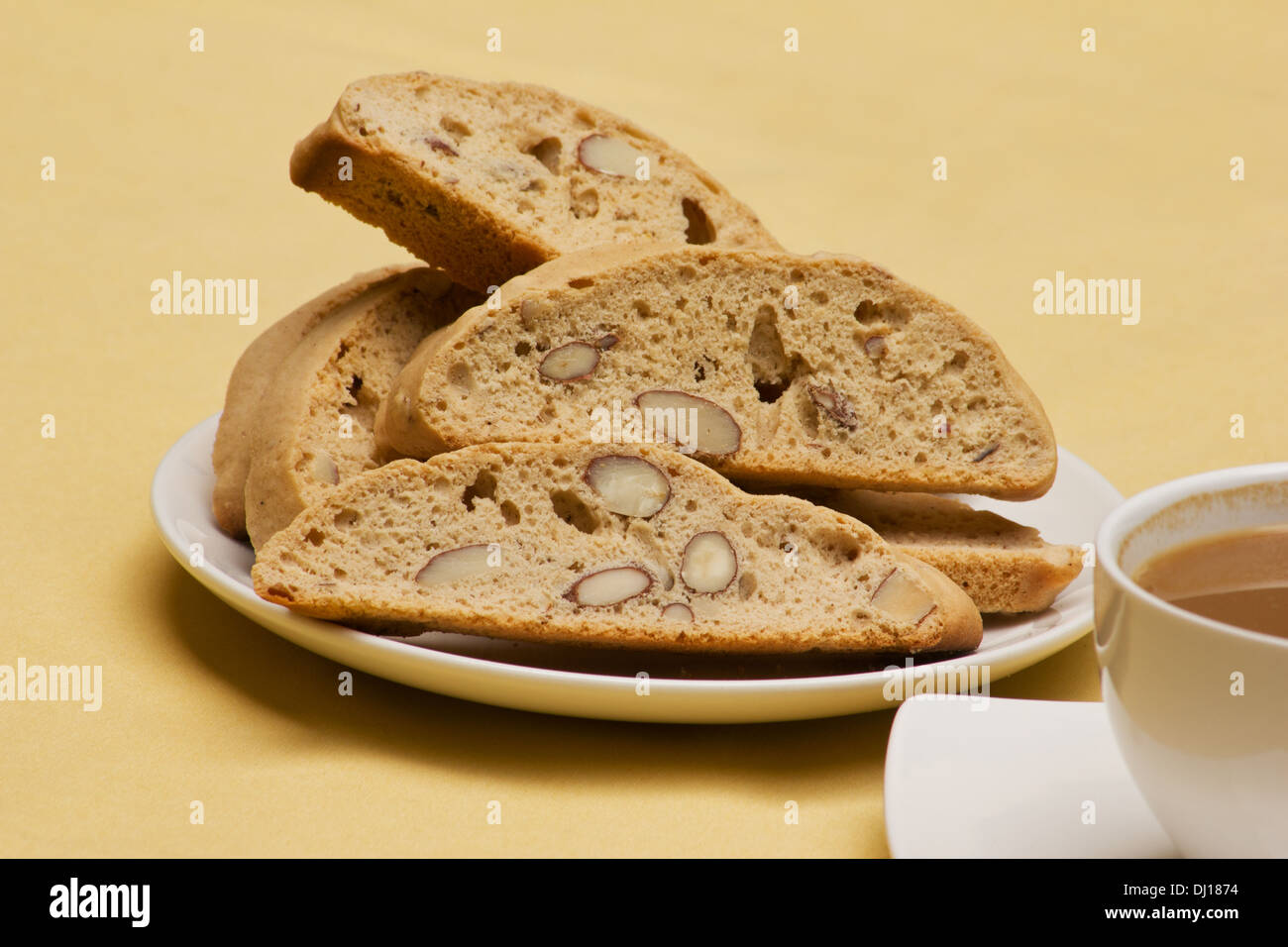 Fresh biscotti with a cup of coffee on yellow background Stock Photo ...