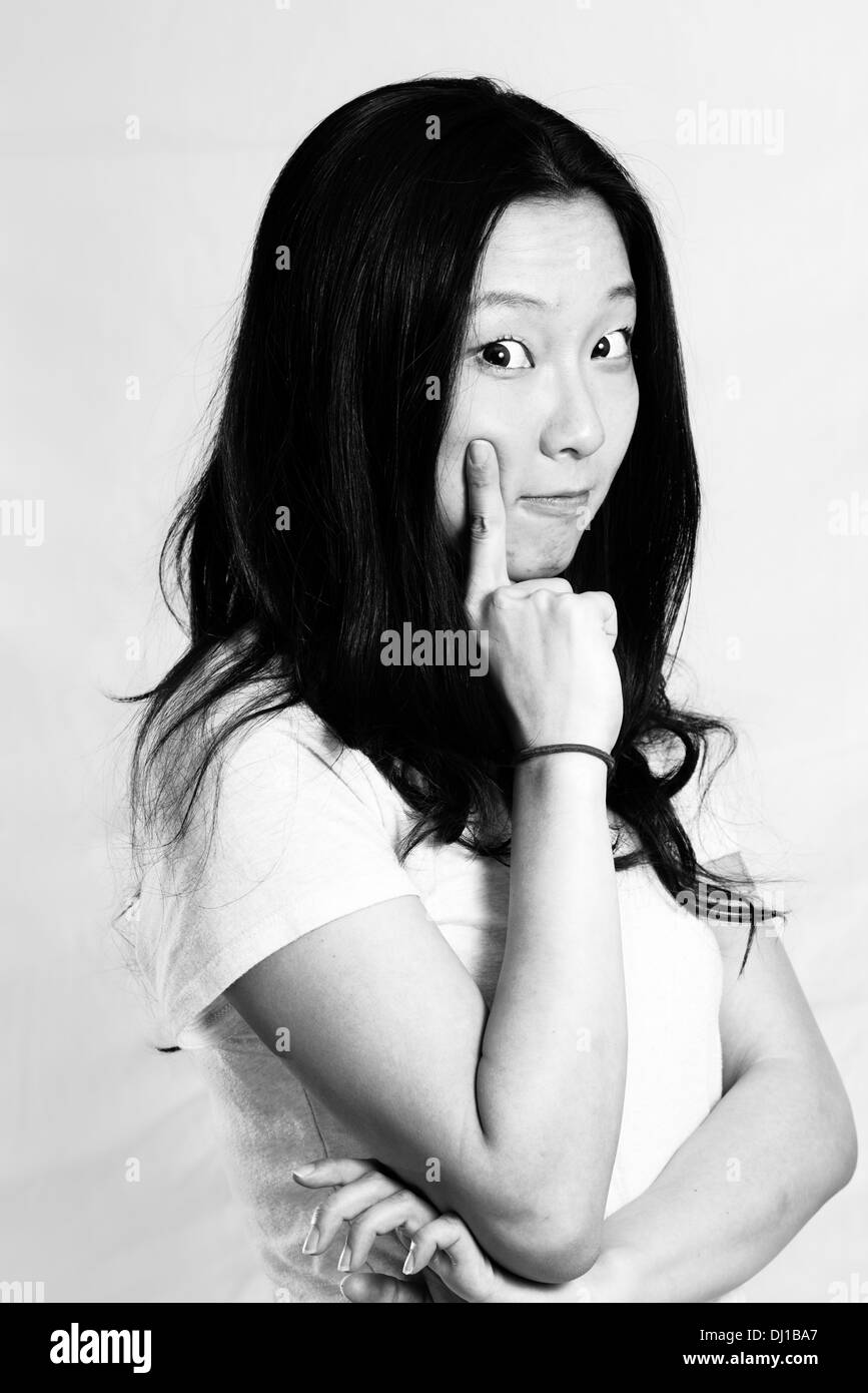 Portrait of cute young woman with cute pose poking face, black and ...