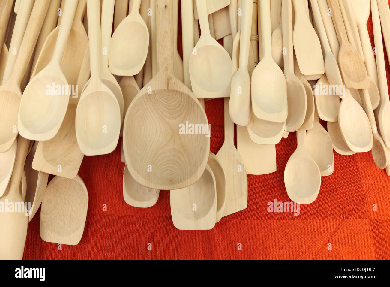 Collection of new wooden spoons on red fabric Stock Photo - Alamy