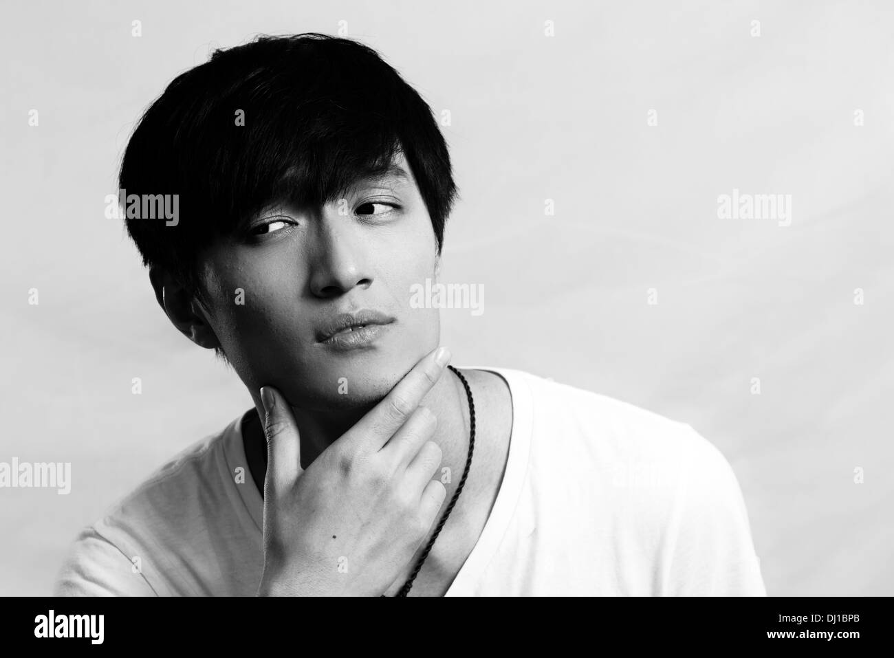 Portrait of handsome young man looking deep in thought, black and white ...