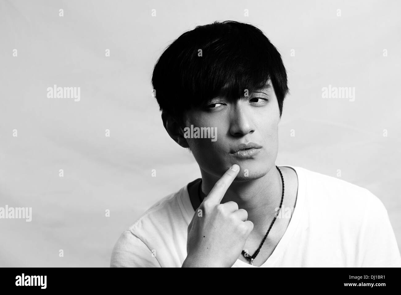 Portrait of handsome young man looking deep in thought, black and white ...