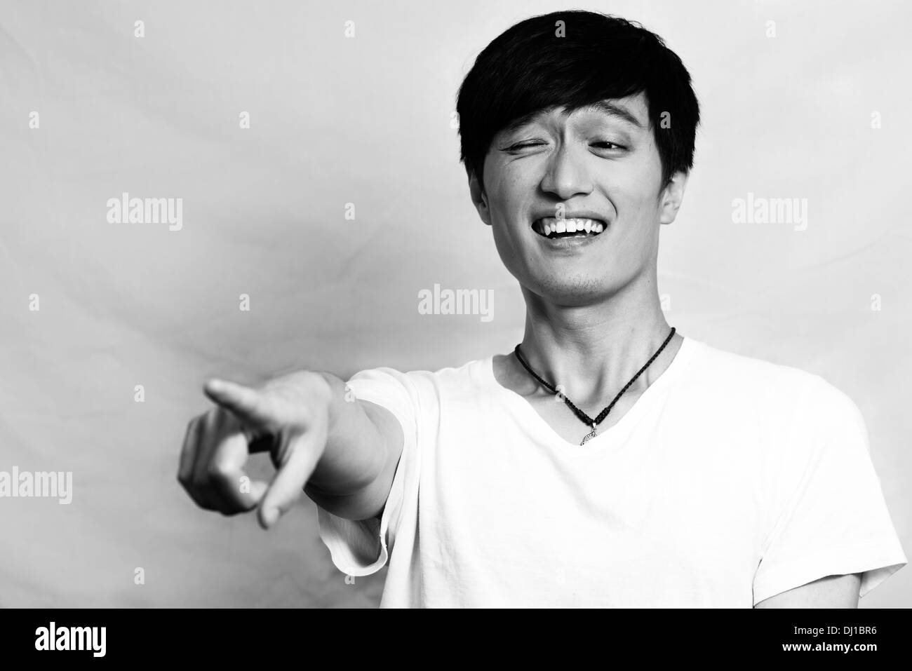 Portrait of condescending young man pointing and laughing, black and ...