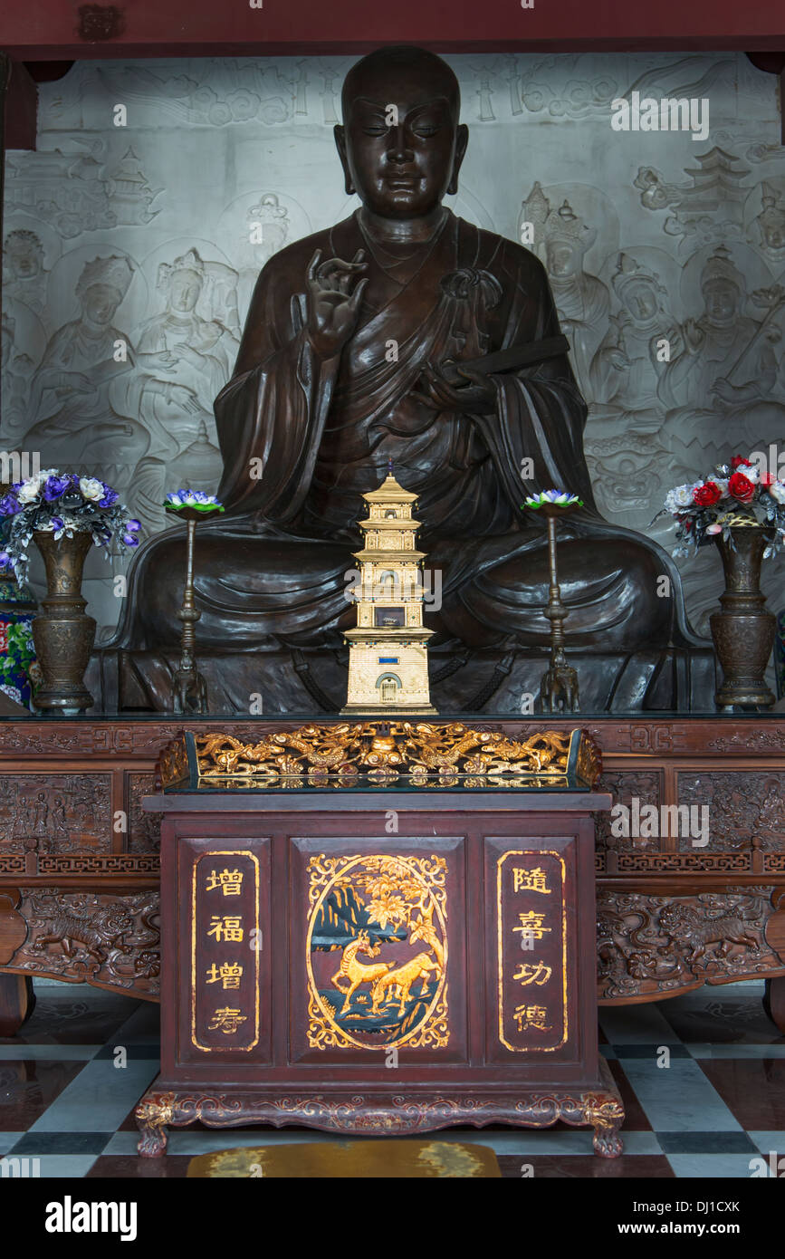Statue Of Buddha With Flowers At A Shrine Stock Photo - Alamy